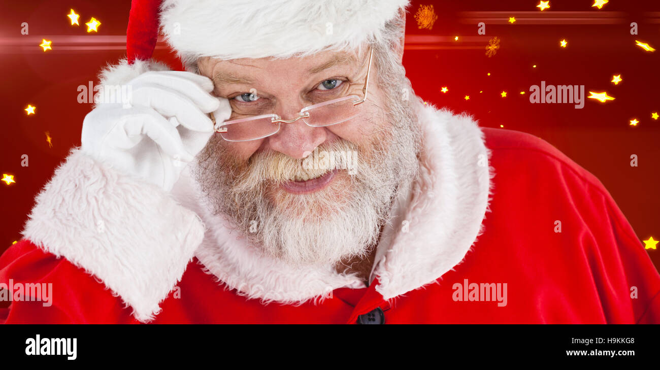 Composite image of santa claus holding spectacles Stock Photo - Alamy