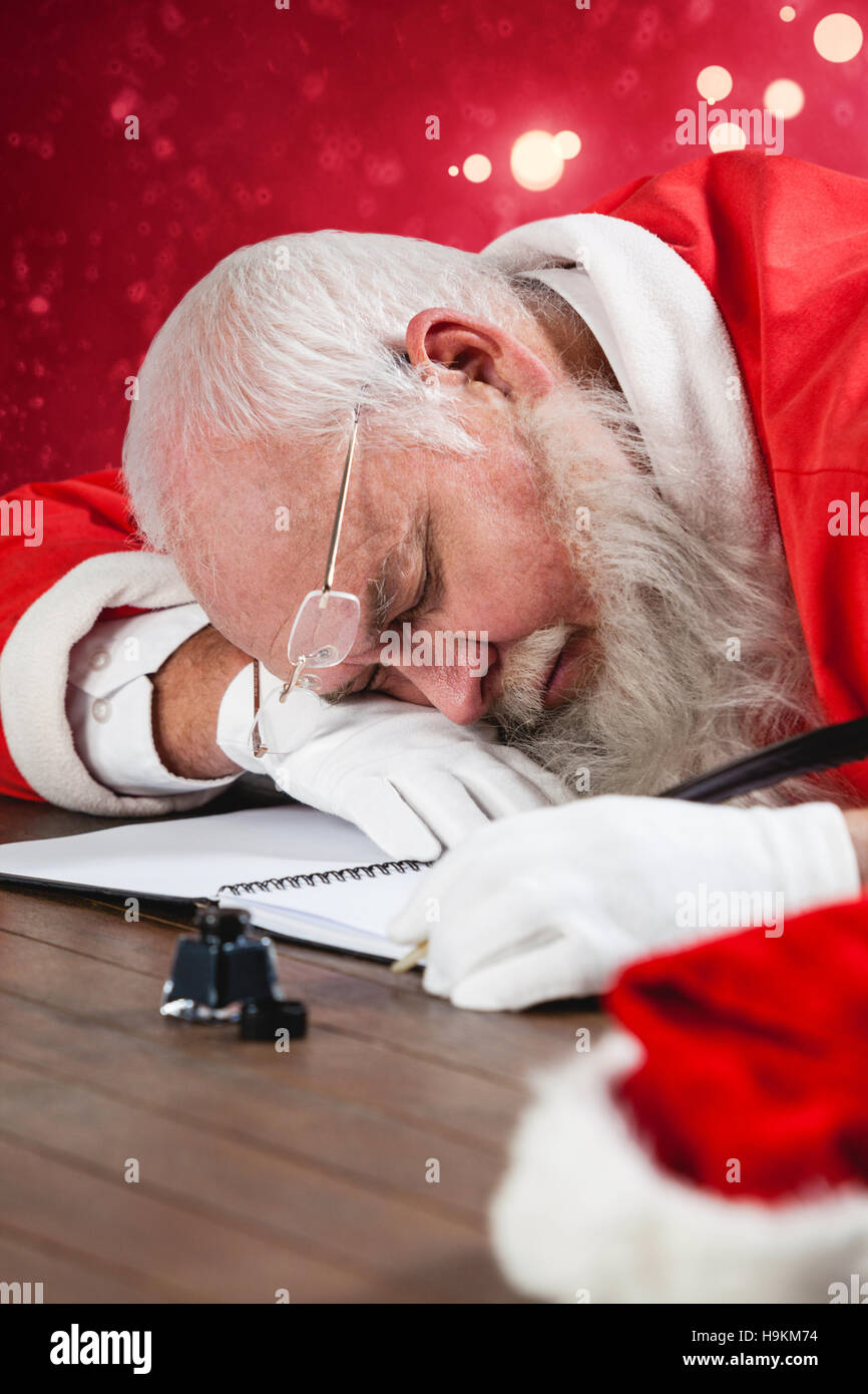 Composite image of tired santa claus napping at desk while writing a ...