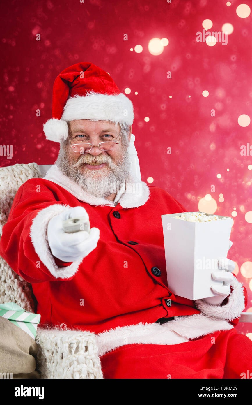 Composite image of santa claus having popcorn while watching tv Stock ...