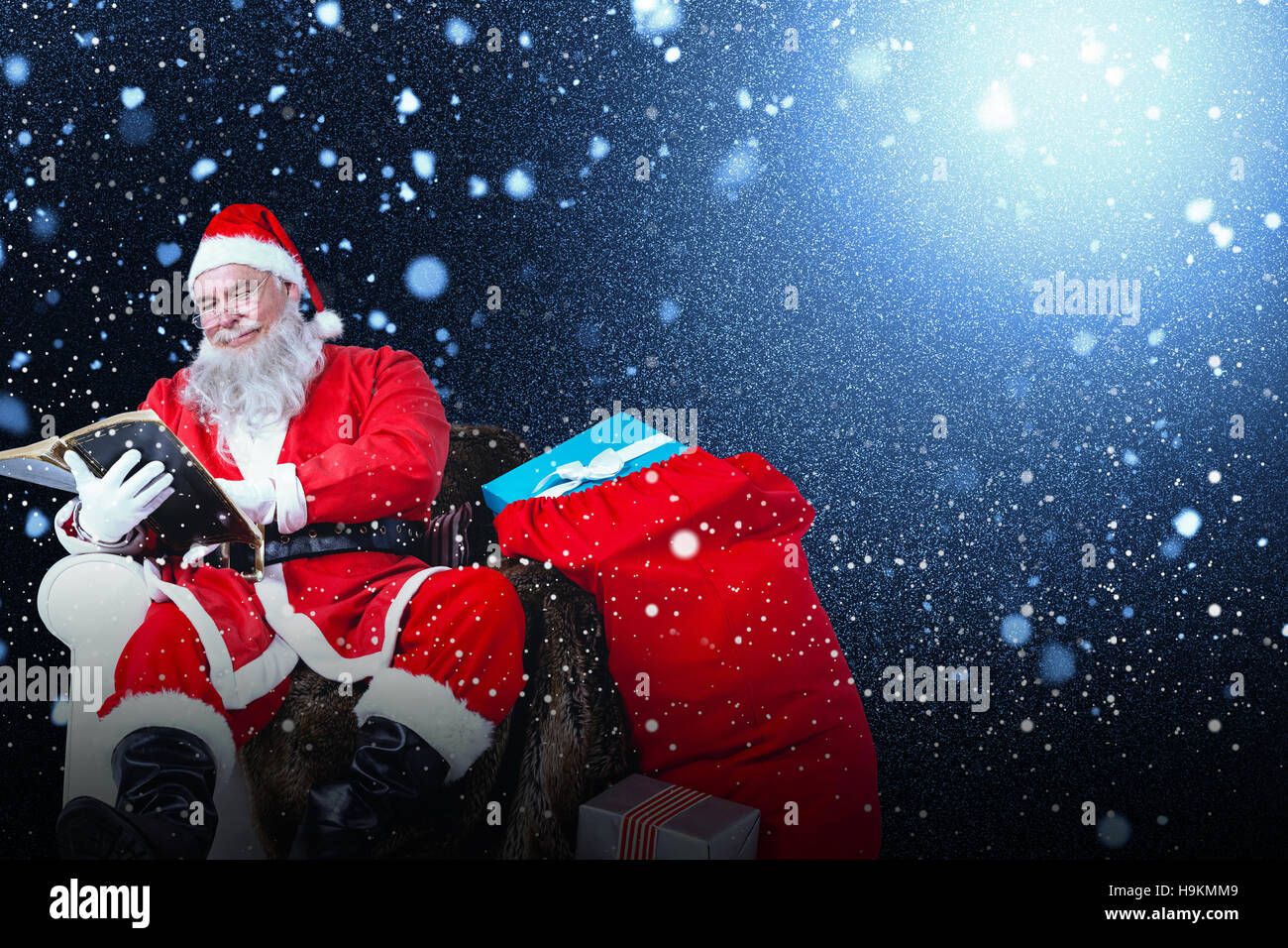 Composite image of santa reading bible with sack of christmas present ...
