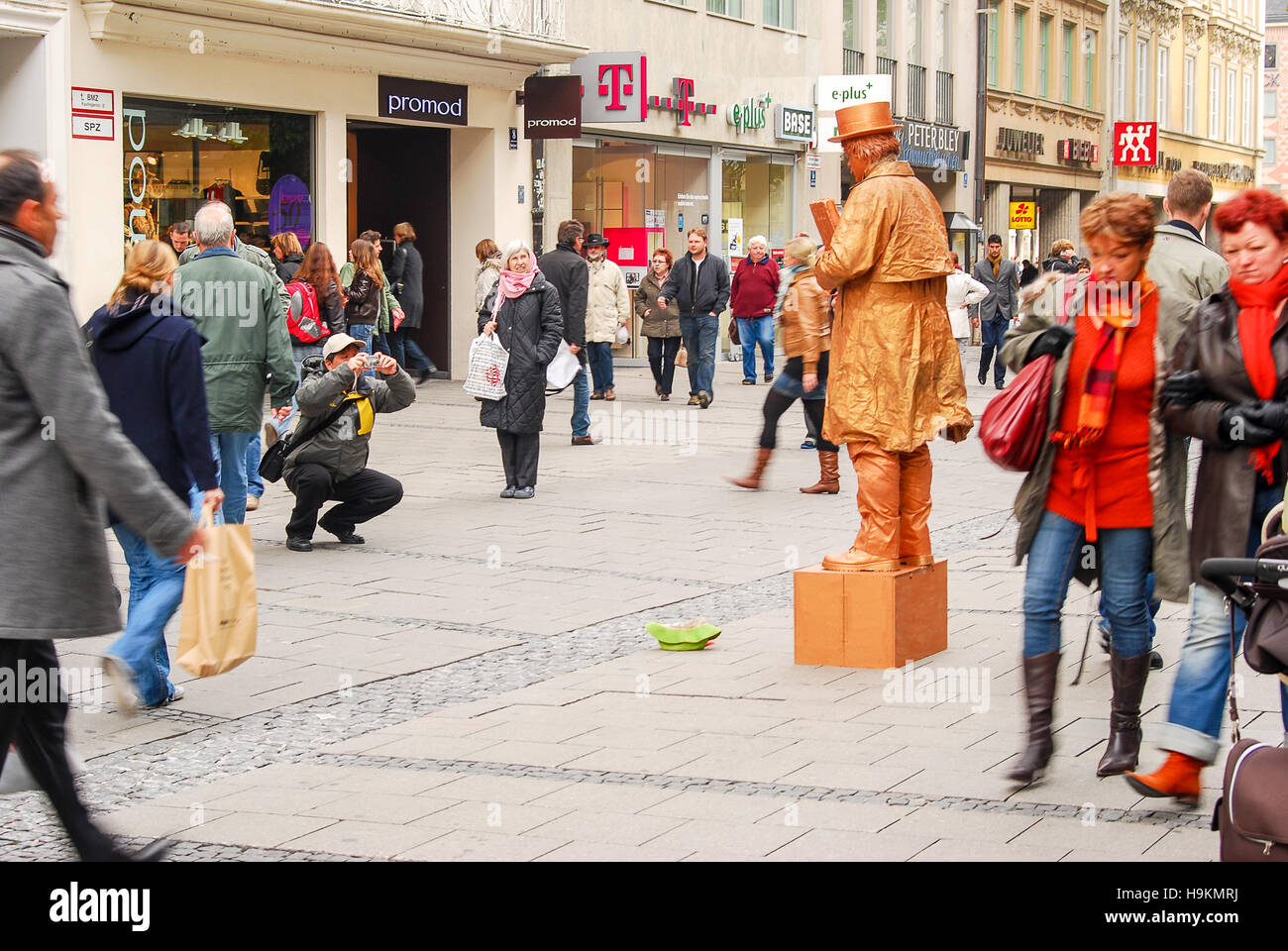 A tourist takes a photo of a man standing like a statue in downtown ...