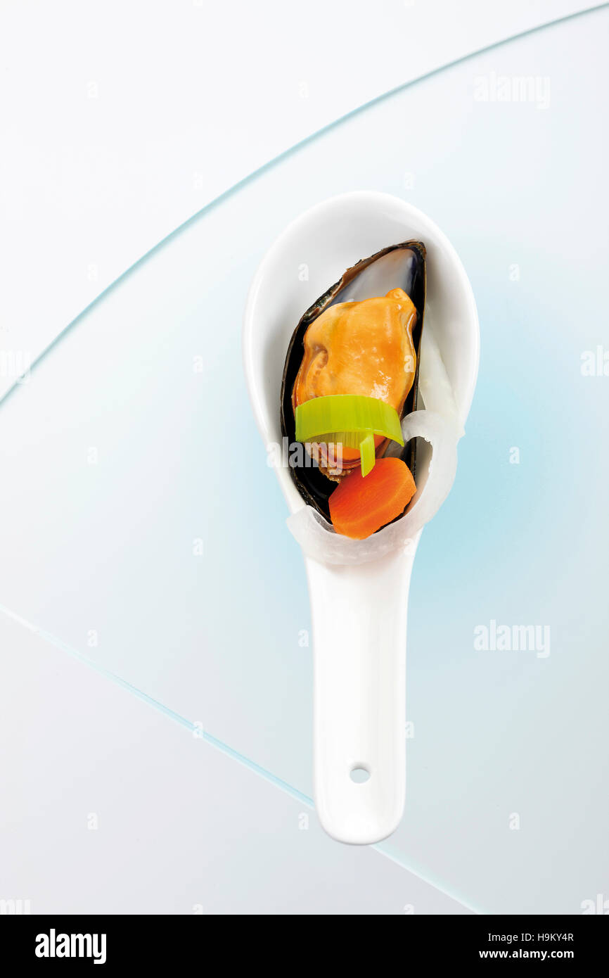 Mussel and vegetable on a porcelain spoon Stock Photo - Alamy