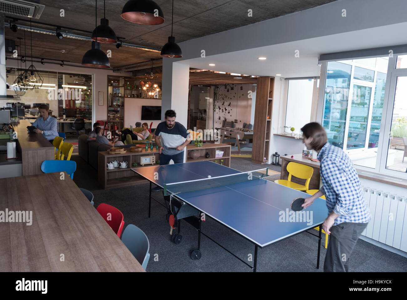 Two young start up business man playing ping pong tennis at modern ...