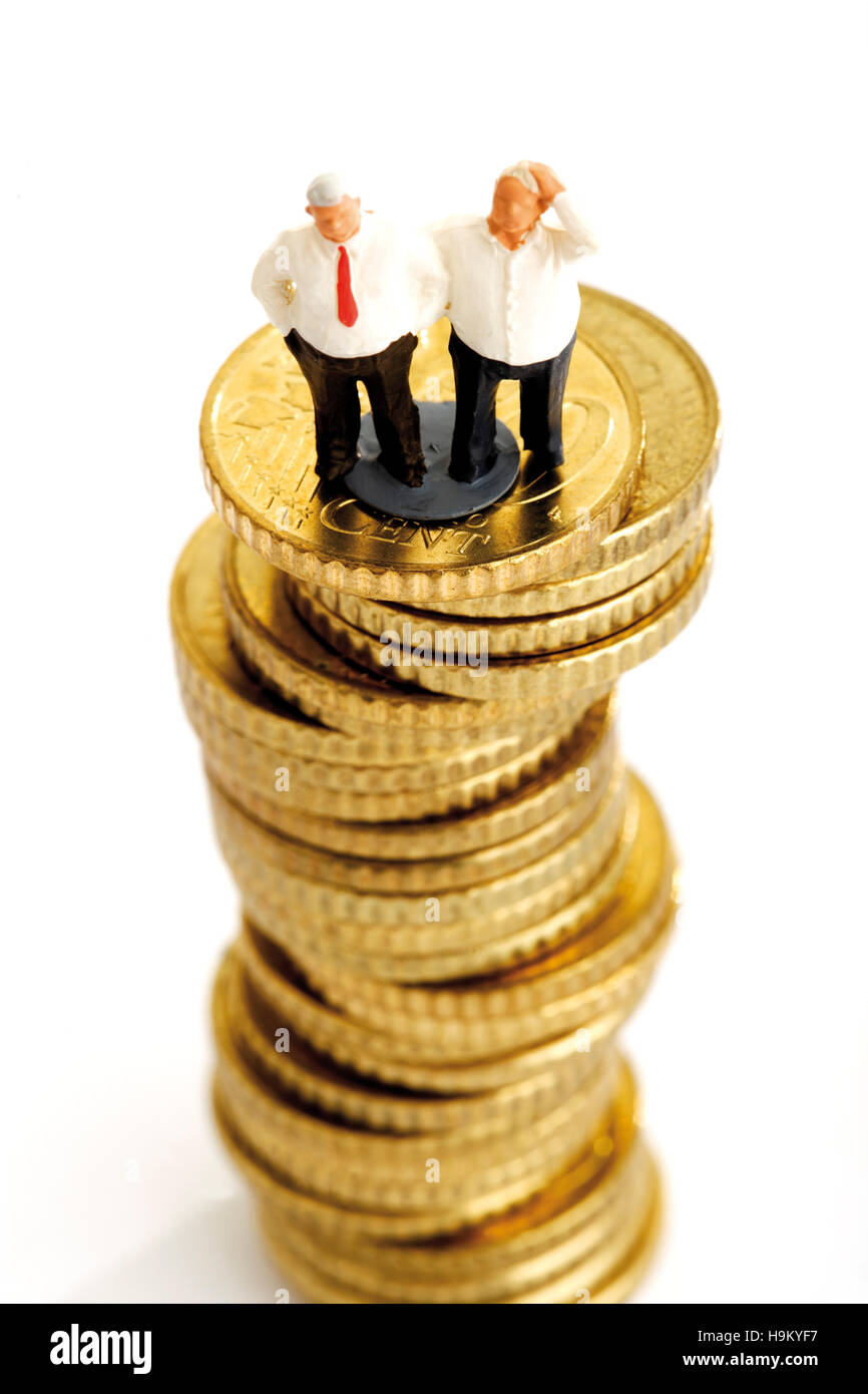 Figurines of two heavy men on a stack of coins Stock Photo - Alamy