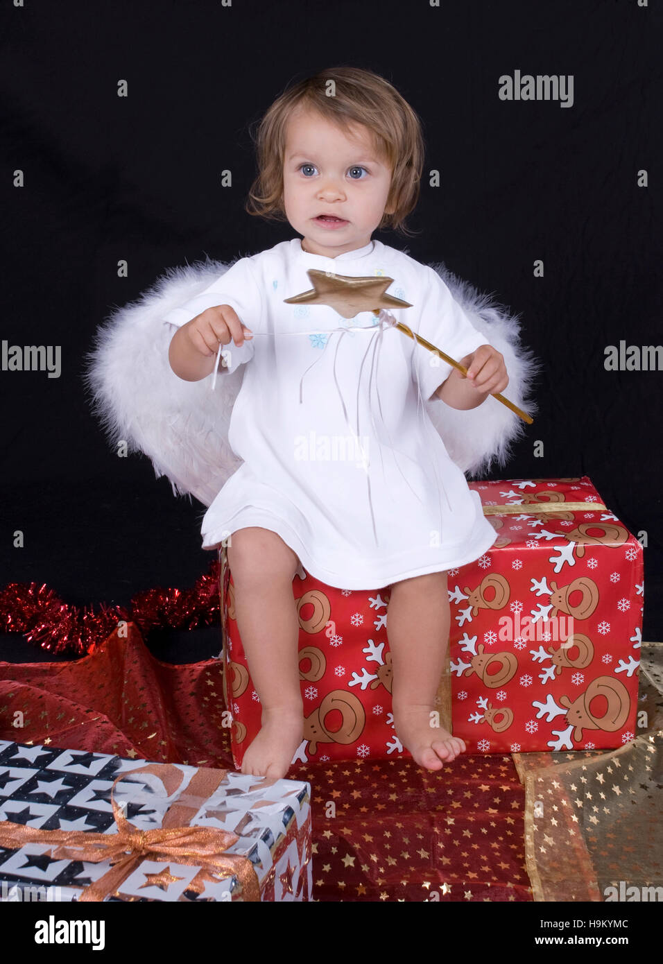 Little girl as a Christmas angel with presents Stock Photo - Alamy