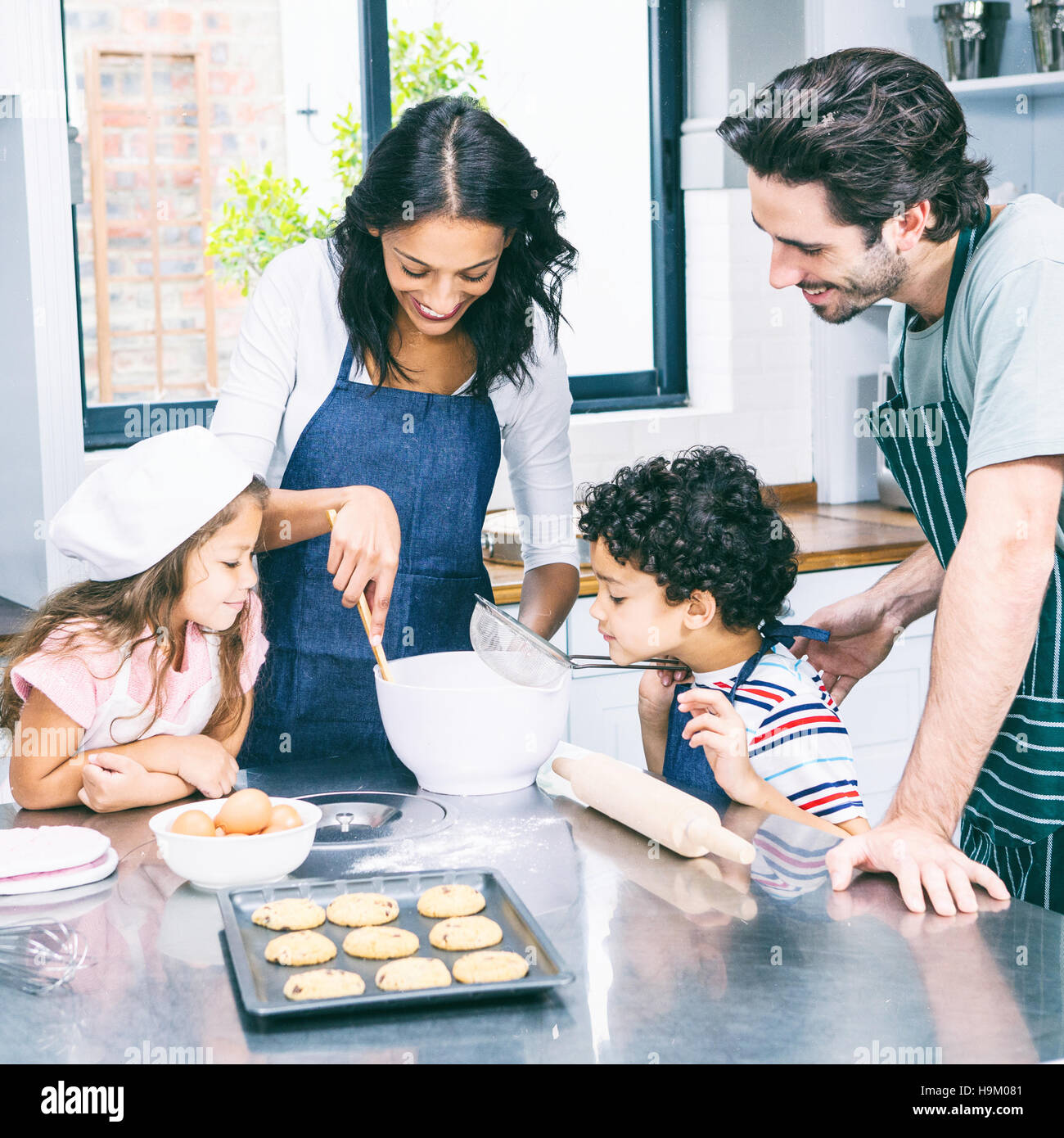 Happy family cooking biscuits together Stock Photo - Alamy