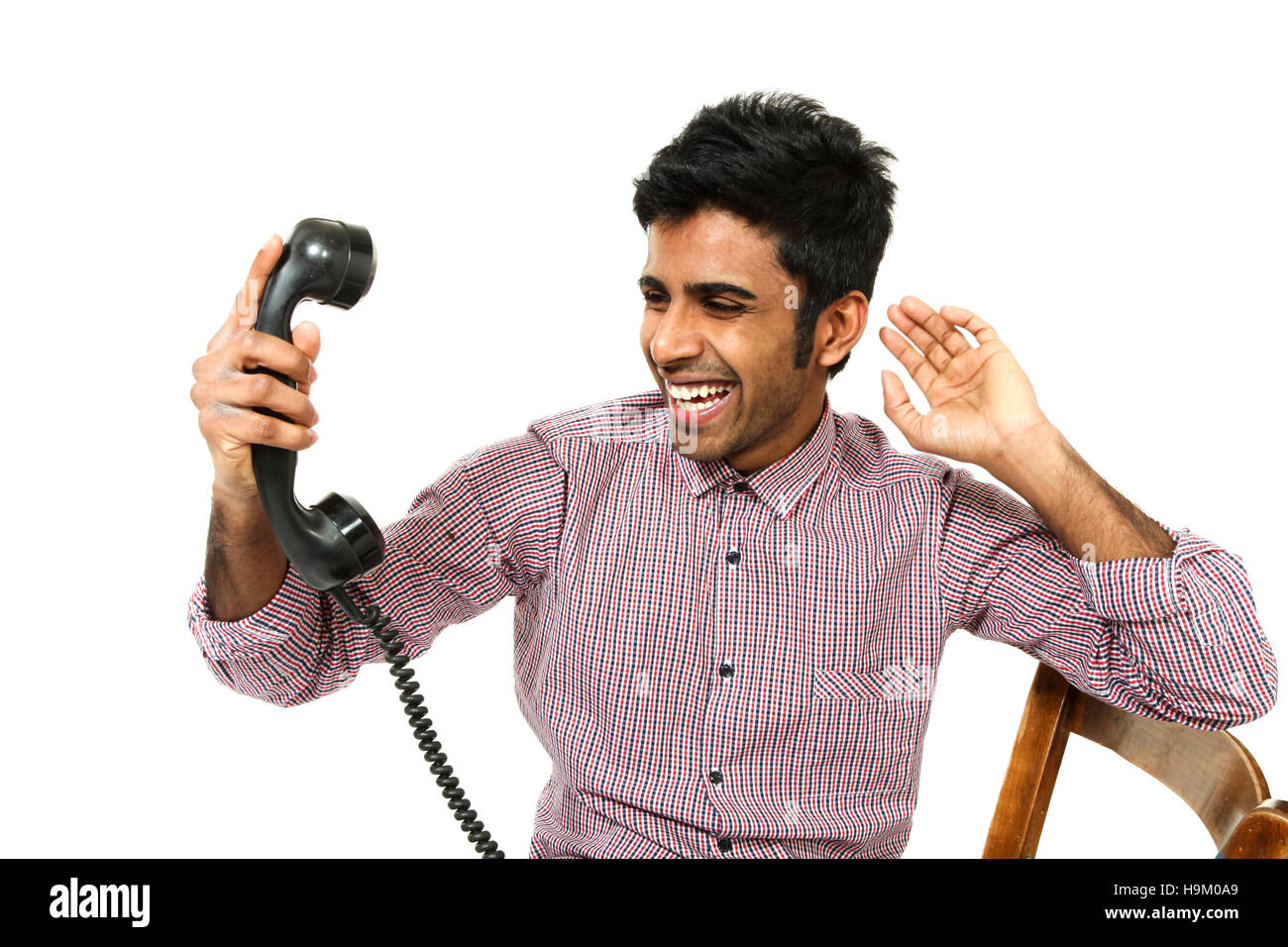 young man struggling with a crazy telephone , portrait on white ...