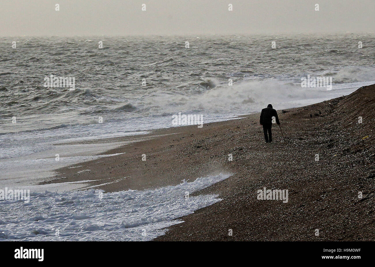A man strolls along the beach in Deal, Kent, as the windy weather ...