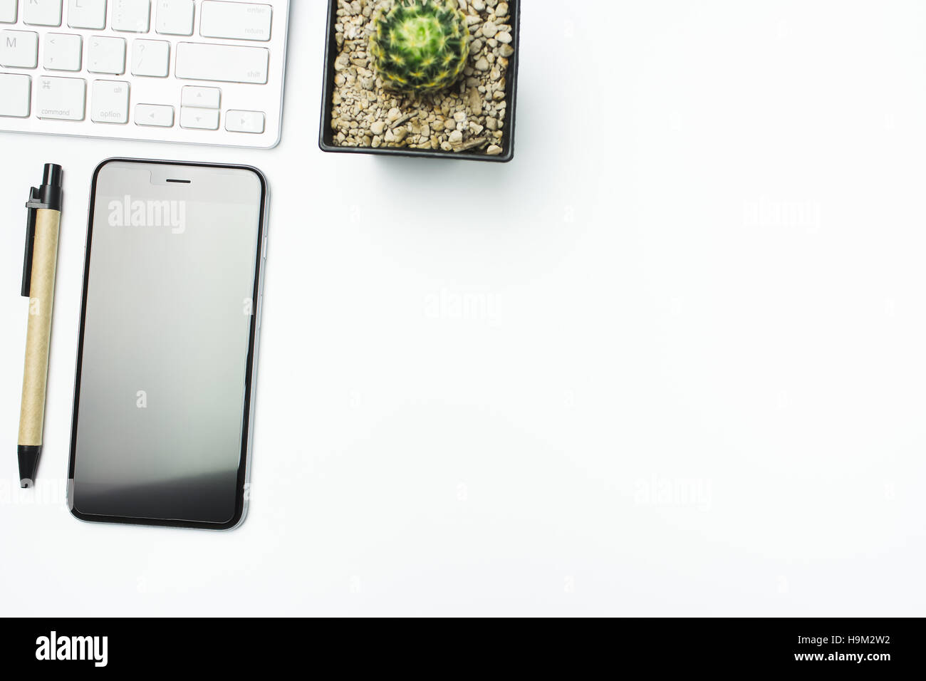 Office workspace with keyboard pen and smartphone on white background ...