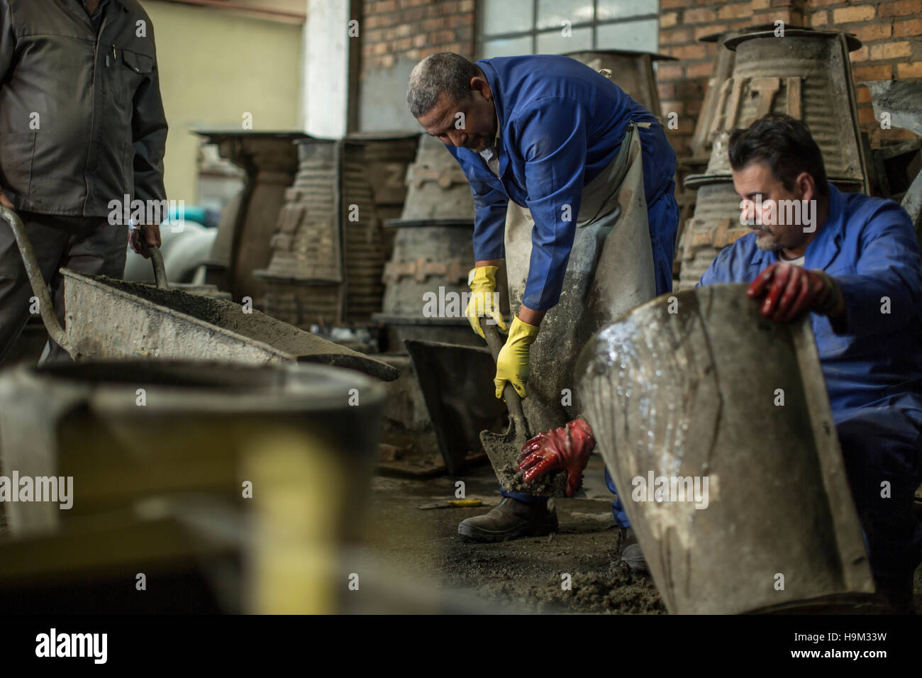 Men working together in industrial pot factory Stock Photo - Alamy