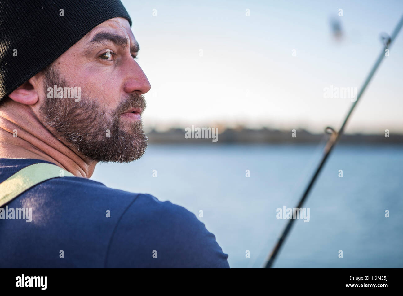 Fisherman catching fish with fishing rod Stock Photo - Alamy
