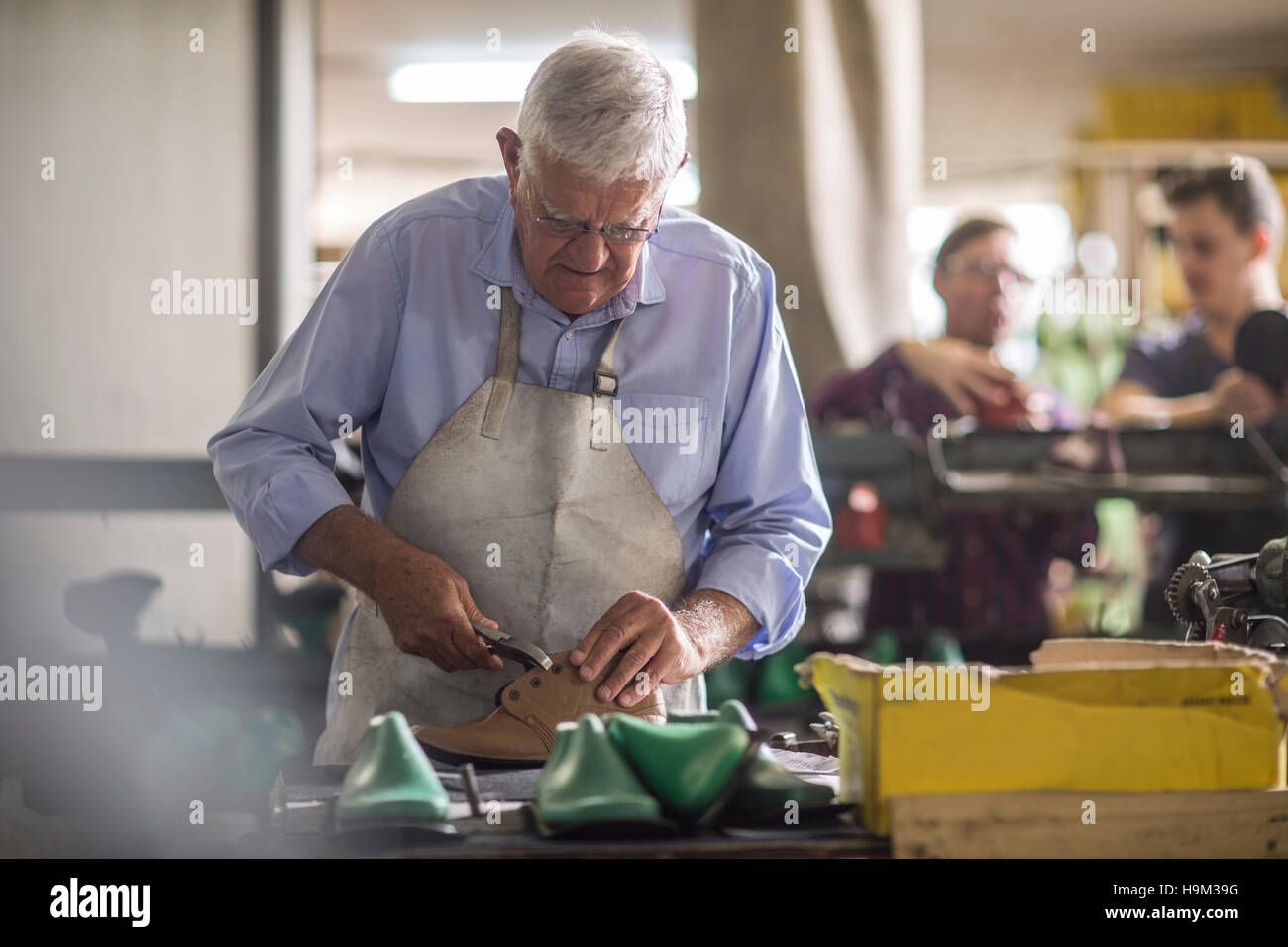 Shoemaker working on shoe in workshop Stock Photo - Alamy