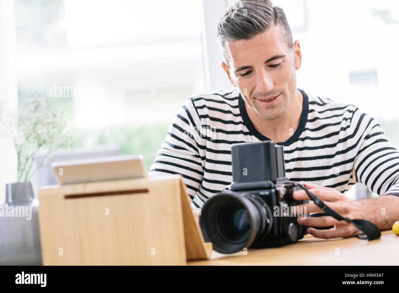 Man at home with camera and tablet Stock Photo - Alamy