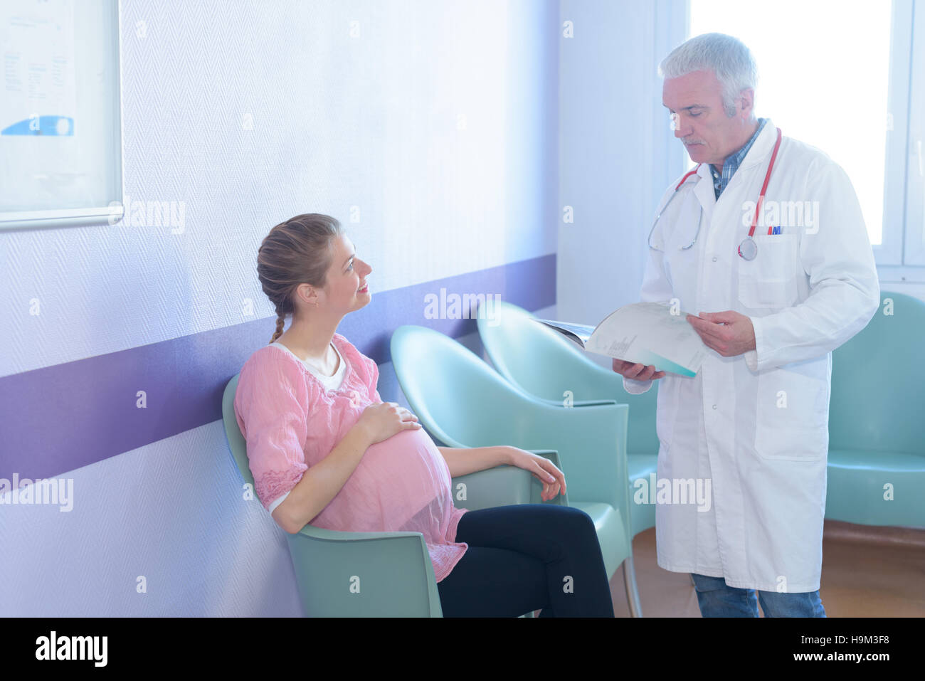 doctor giving news to a woman in hospital waiting room Stock Photo - Alamy