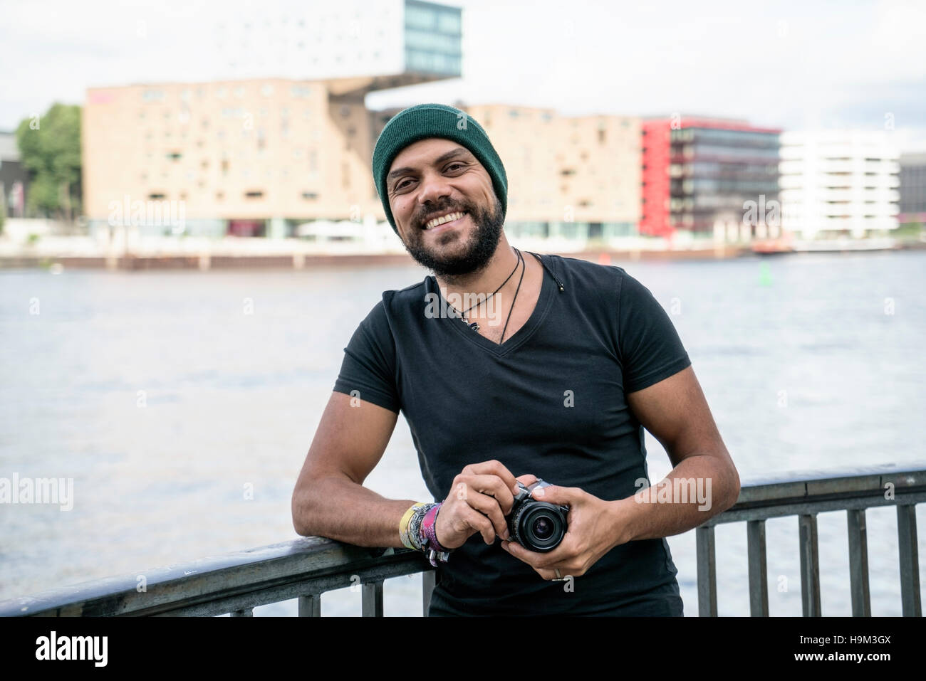 Germany, Berlin, portrait of happy man with camera Stock Photo - Alamy