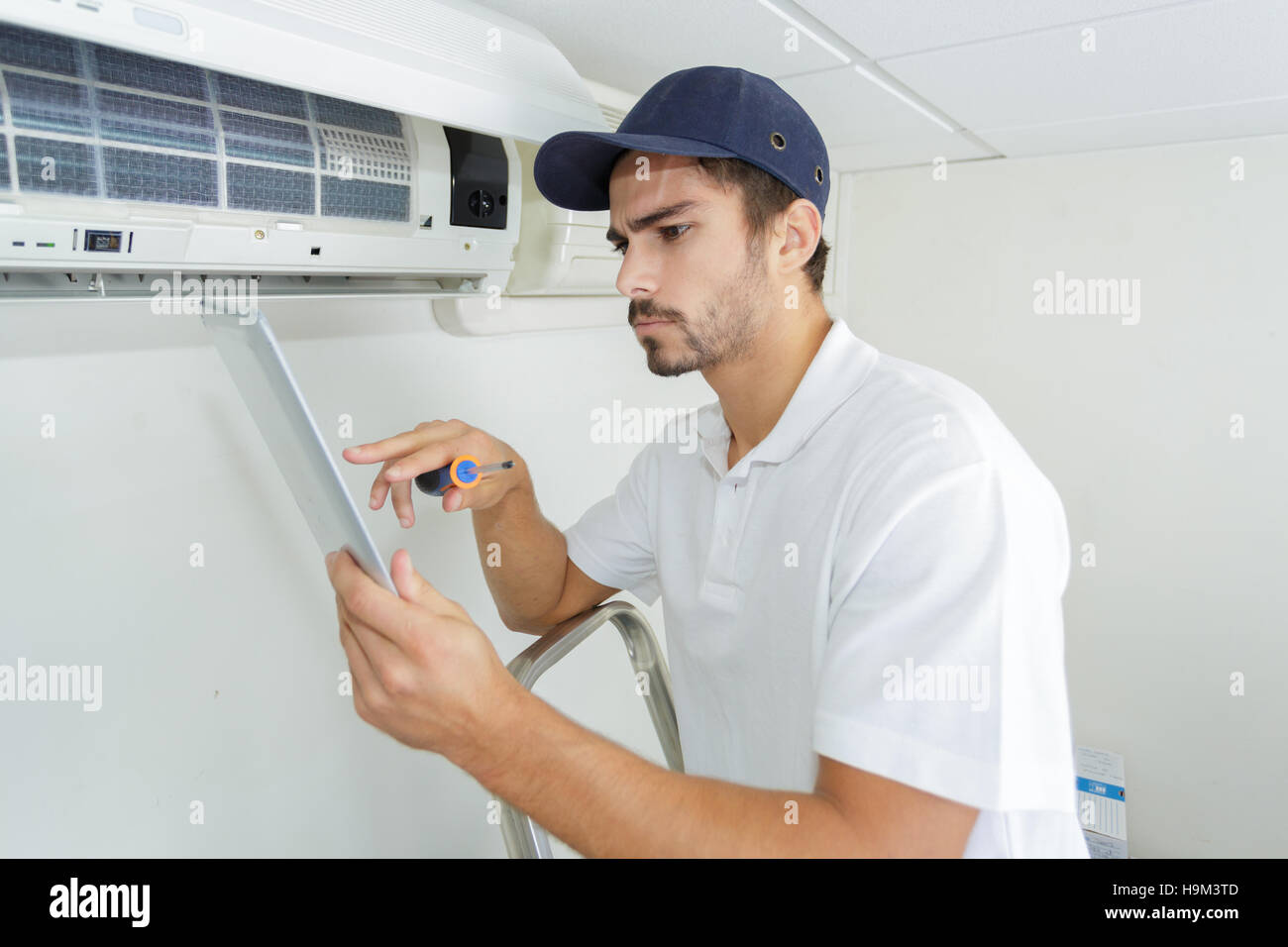 young contractor working carefully and seriously at clients office ...
