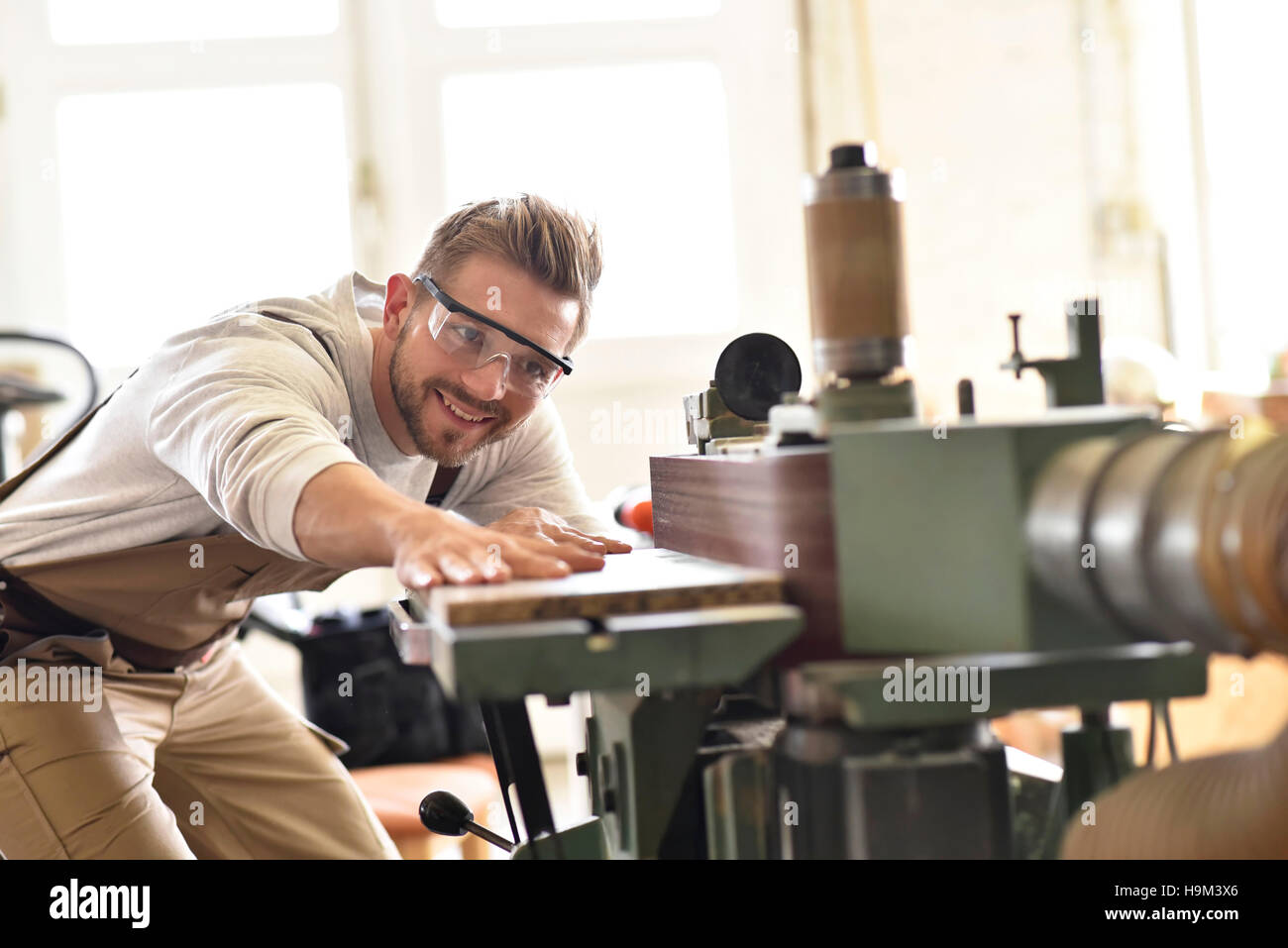 Carpenter using belt sander in his workshop Stock Photo - Alamy