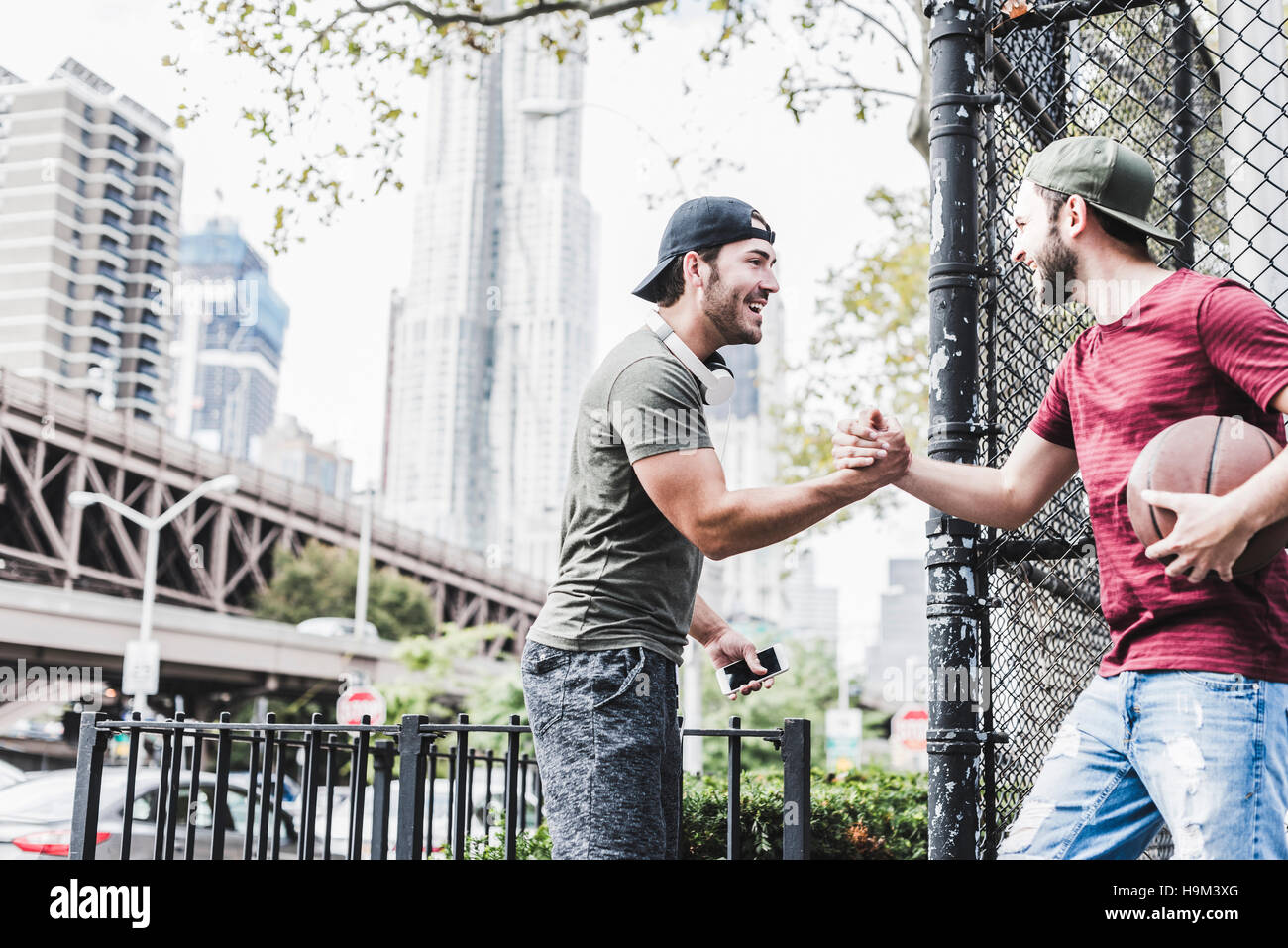 Two young men with basketball meeting outdoors Stock Photo - Alamy