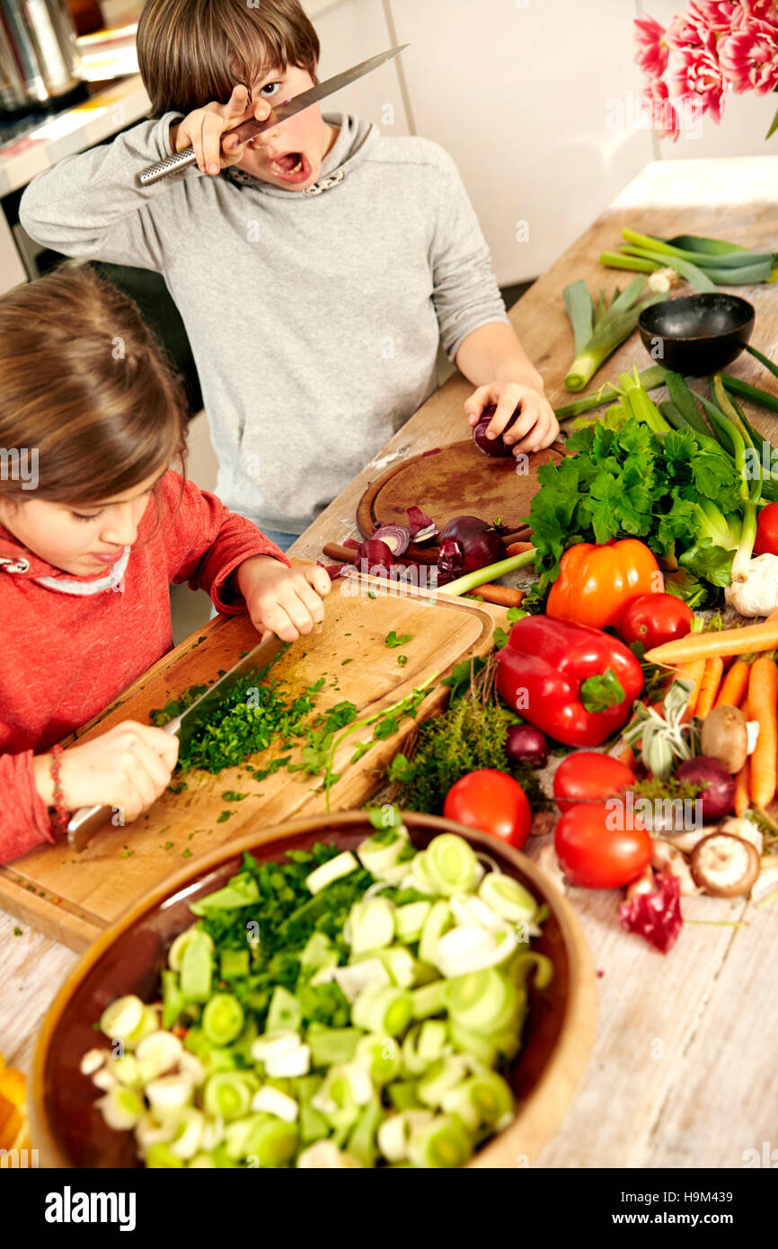 Boy and girl chopping vegetables in the kitchen Stock Photo - Alamy