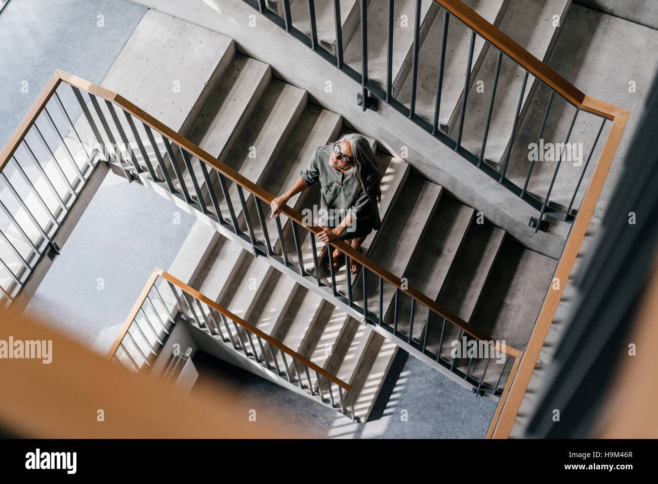 Woman with long grey hair in staircase Stock Photo - Alamy