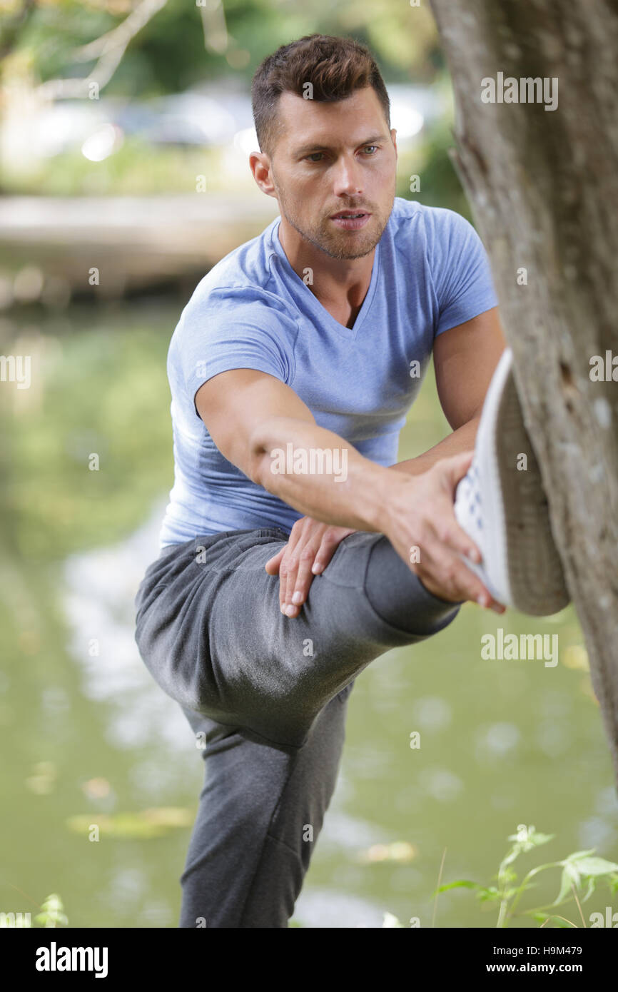 sportsman warming up and stretching legs on three Stock Photo - Alamy