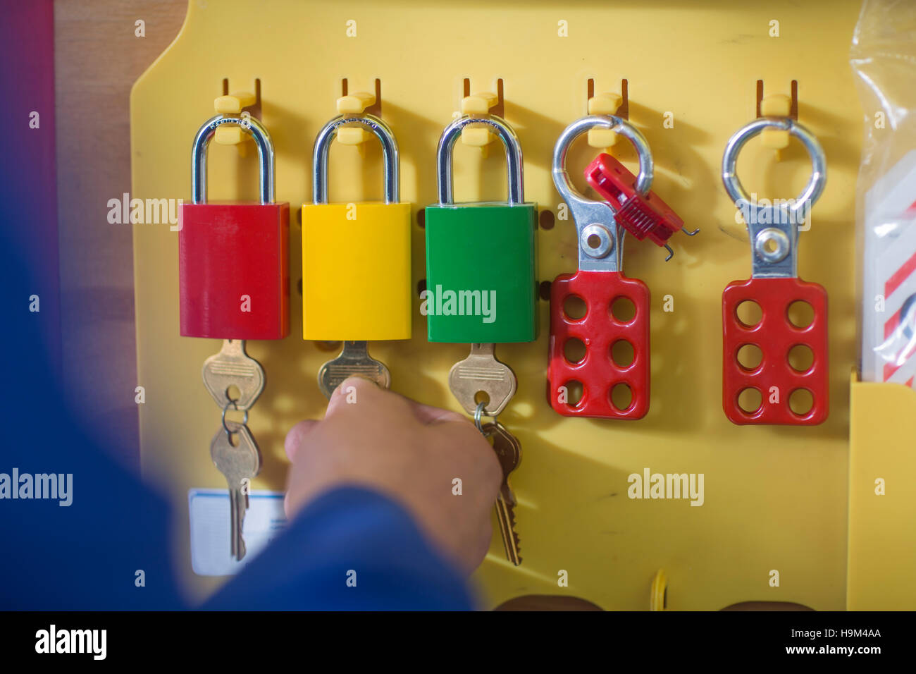 Hand taking lock from lockout station Stock Photo - Alamy