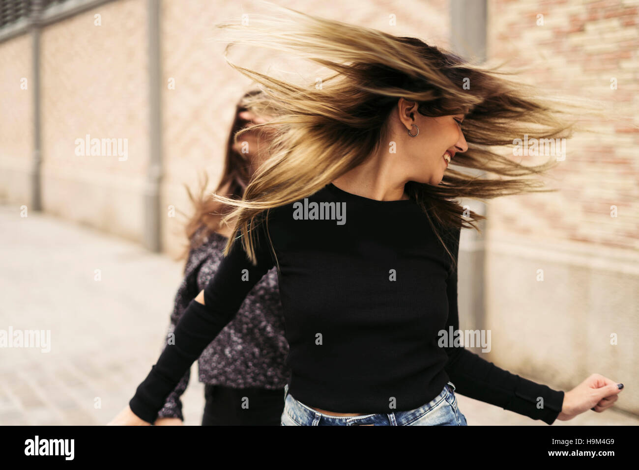 Two women tossing her hair Stock Photo - Alamy