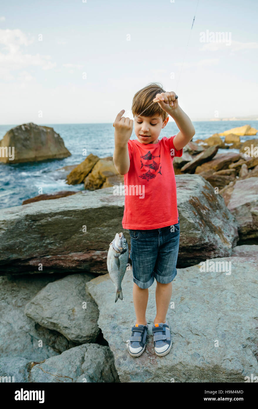 Boy holding fish on fishing line Stock Photo - Alamy