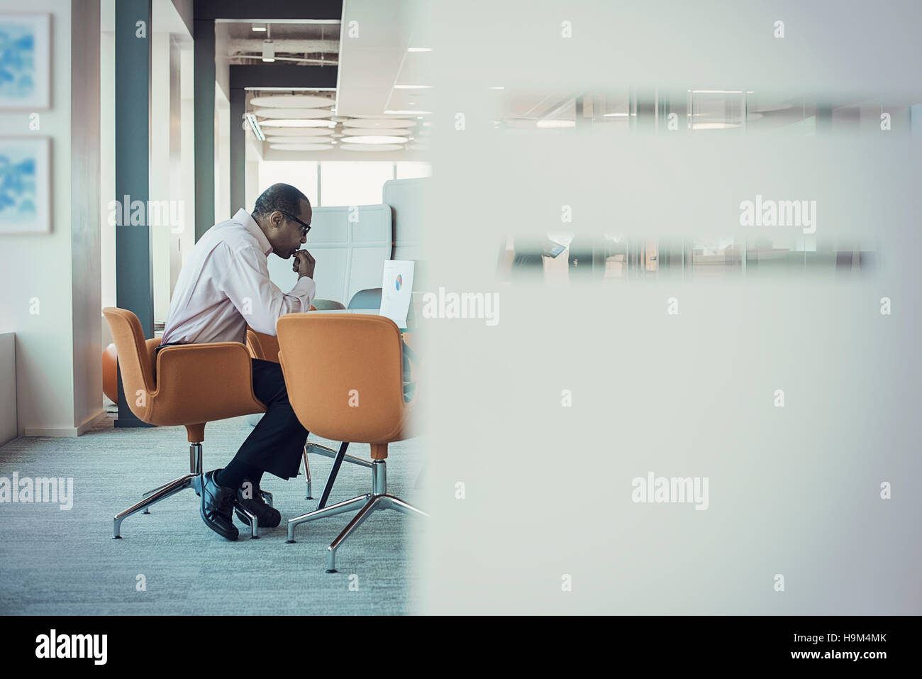 Businessman working alone in office Stock Photo - Alamy