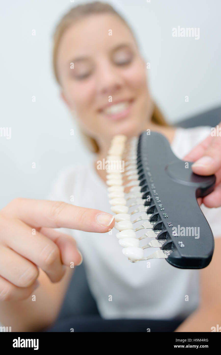 Lady pointing to tooth on color match sampler Stock Photo - Alamy