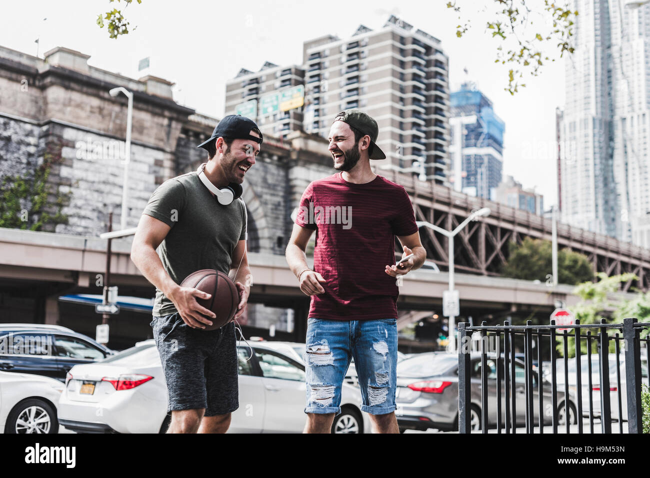 Two young men with basketball having fun Stock Photo - Alamy