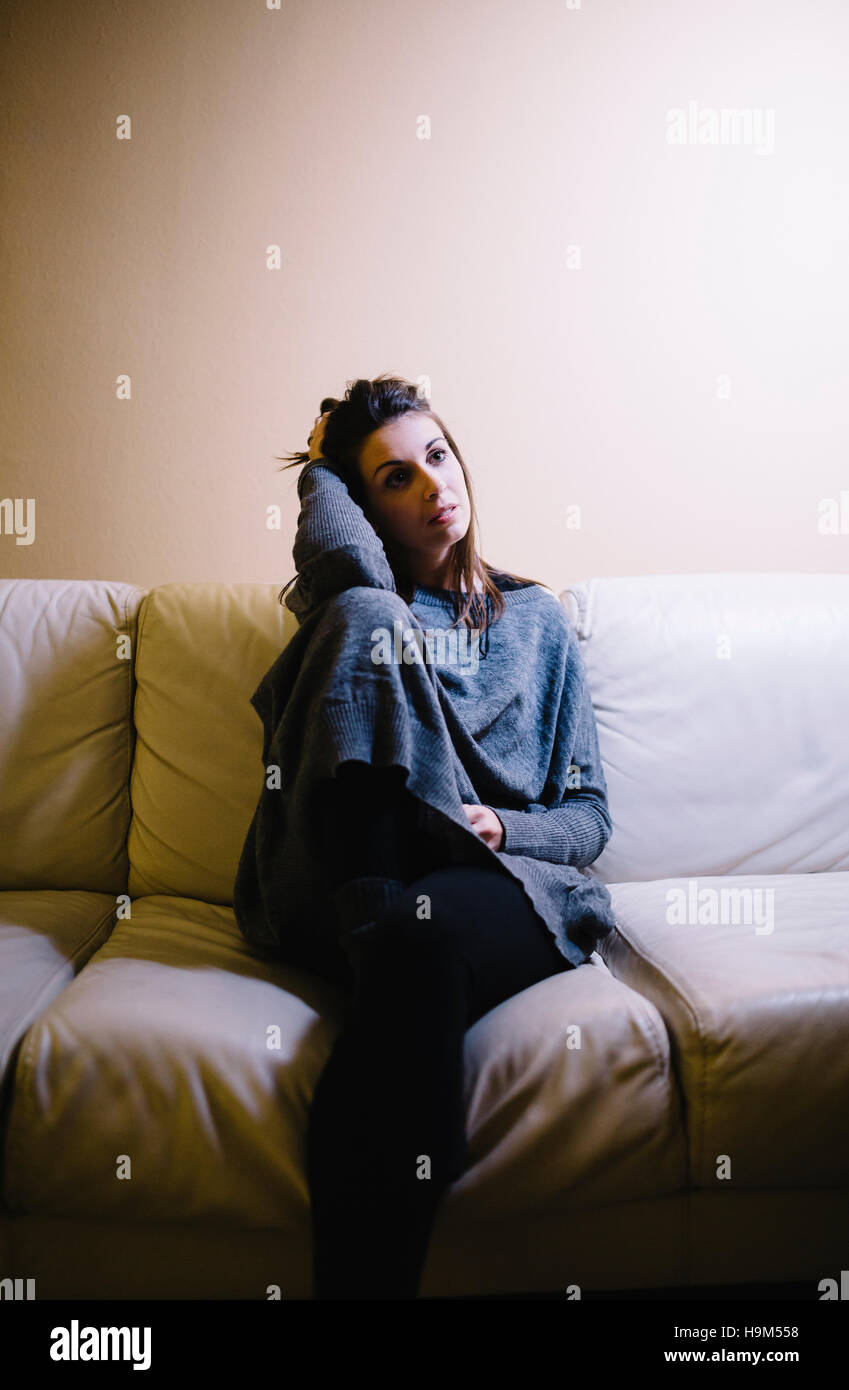 Portrait of lonely woman sitting on the couch at night Stock Photo - Alamy