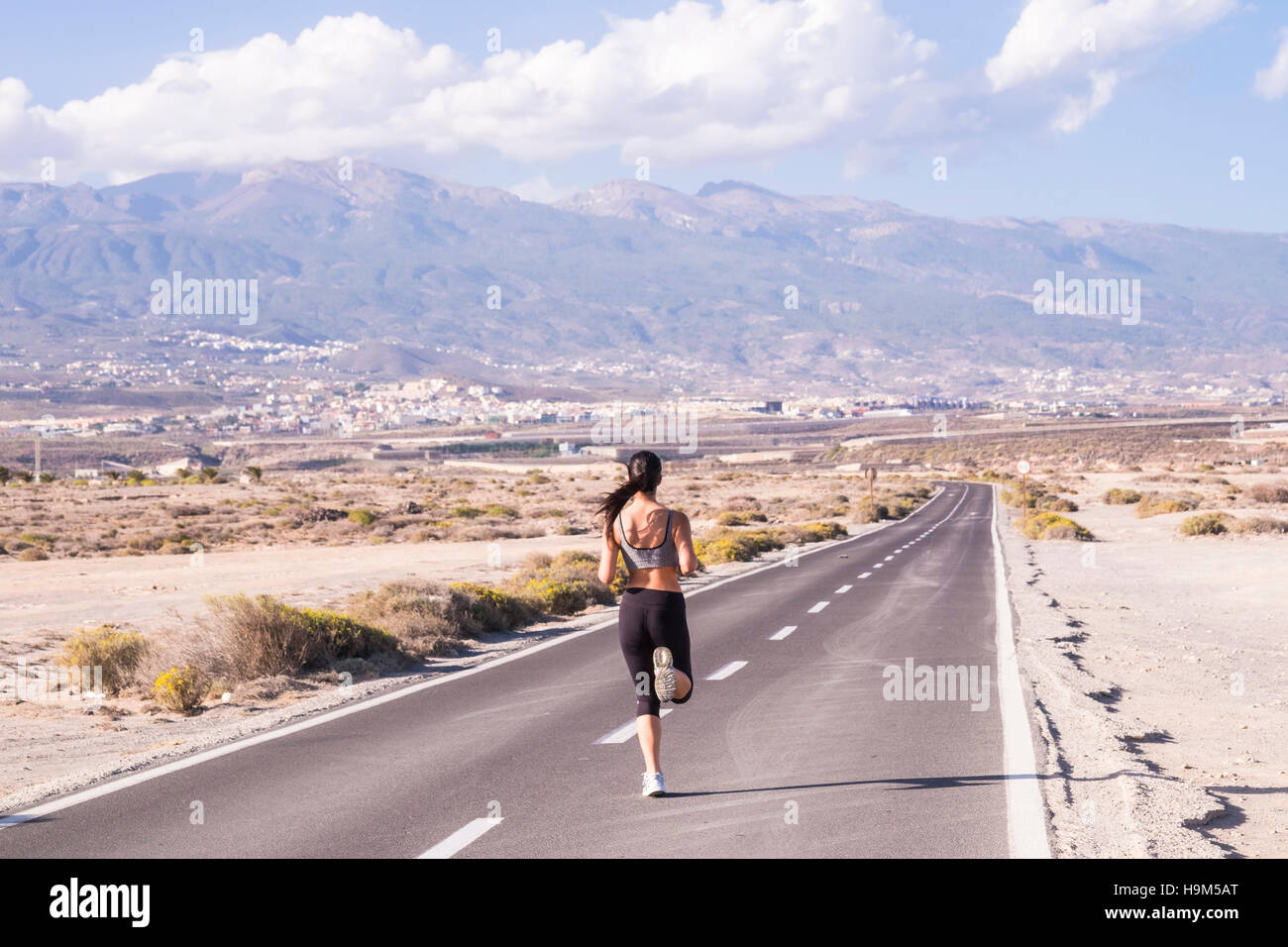 young woman running on long road Stock Photo - Alamy