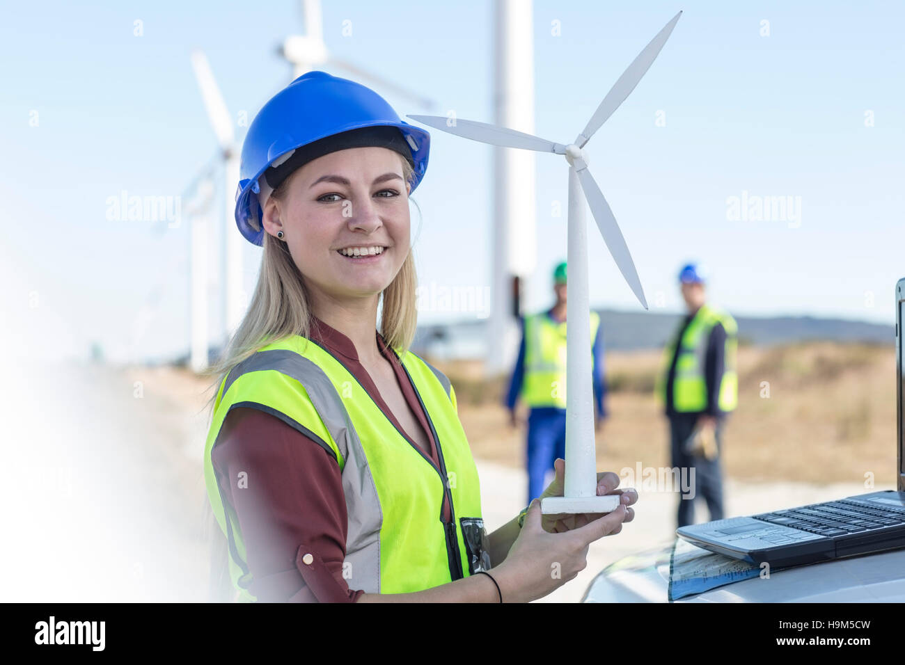 Female engineer working on site, holding model of wind turbine Stock ...