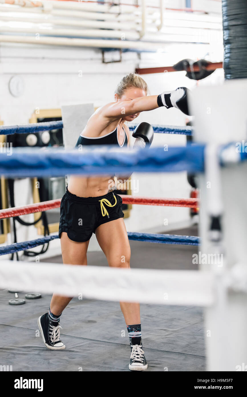 Female boxer punching in boxing ring Stock Photo - Alamy