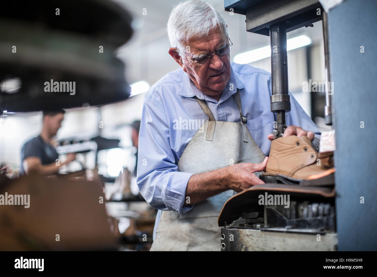 Shoemaker working on shoe in workshop Stock Photo - Alamy