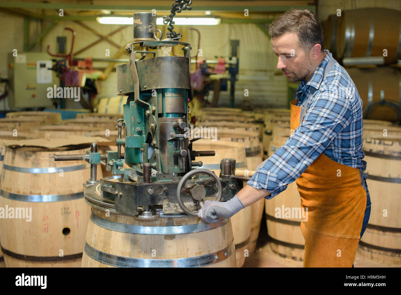 Cooper using machine to make barrel Stock Photo - Alamy