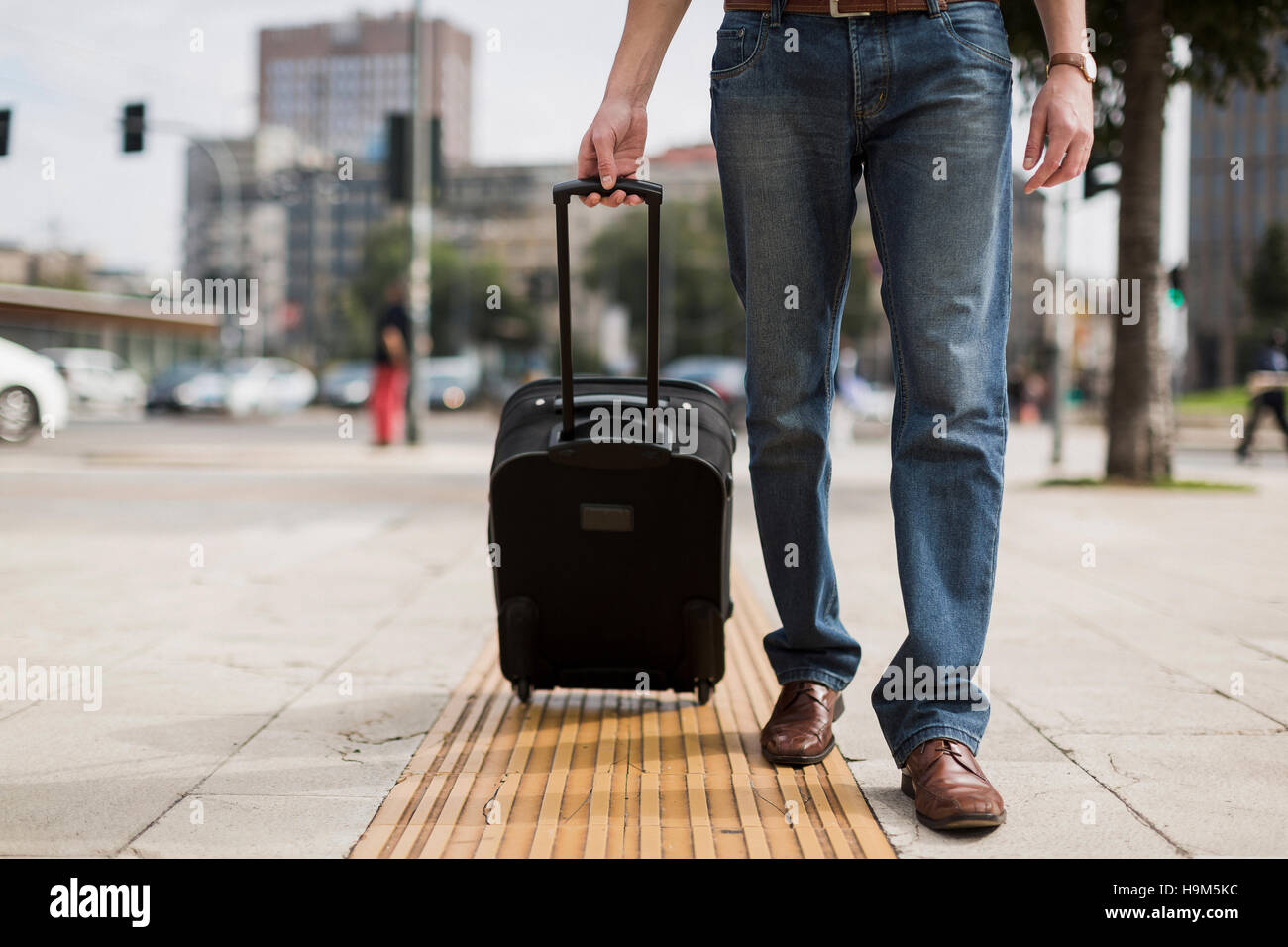 Legs of businessman with suitcase on pavement Stock Photo - Alamy