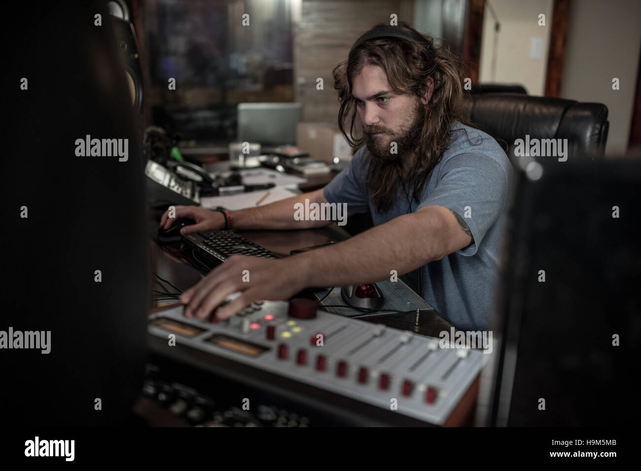 Audio engineer adjusting mixer at recording studio Stock Photo - Alamy