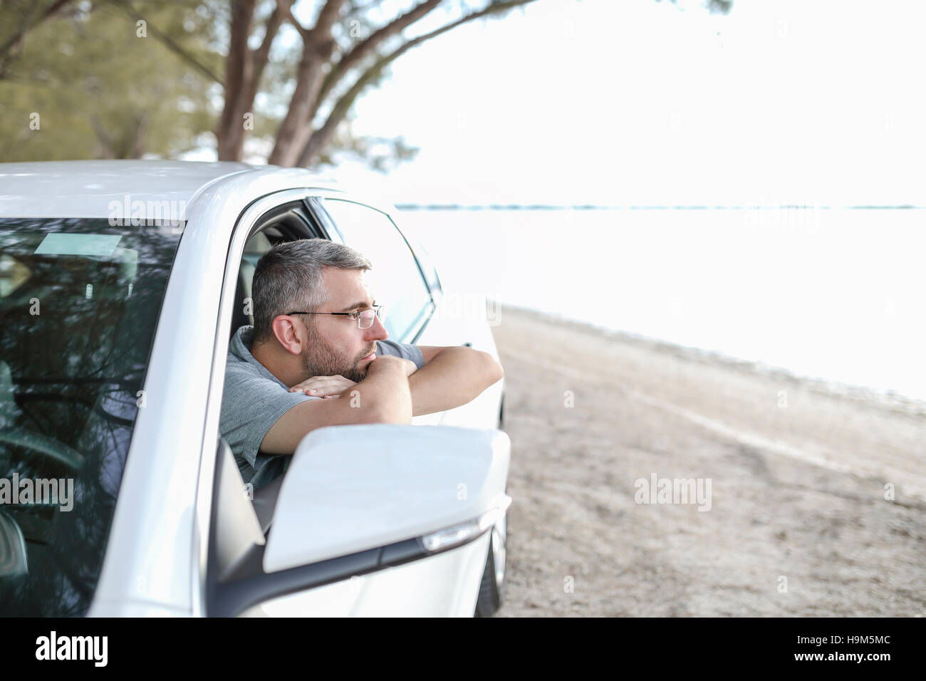 Man sitting in car, taking a break Stock Photo - Alamy