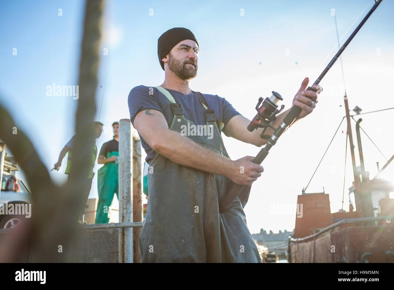 Fisherman catching fish with fishing rod Stock Photo - Alamy