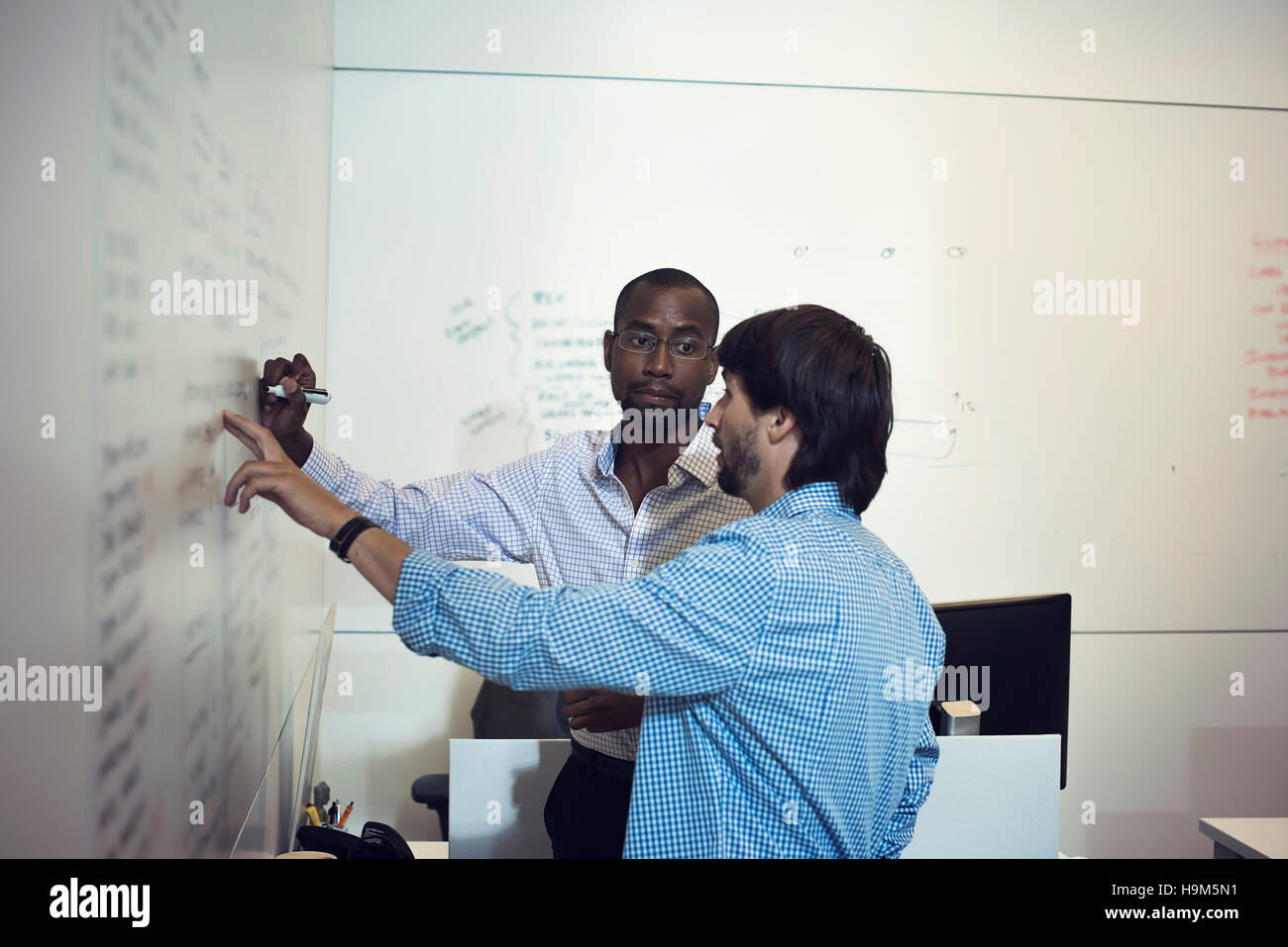 Business people writing on whiteboard in office Stock Photo - Alamy