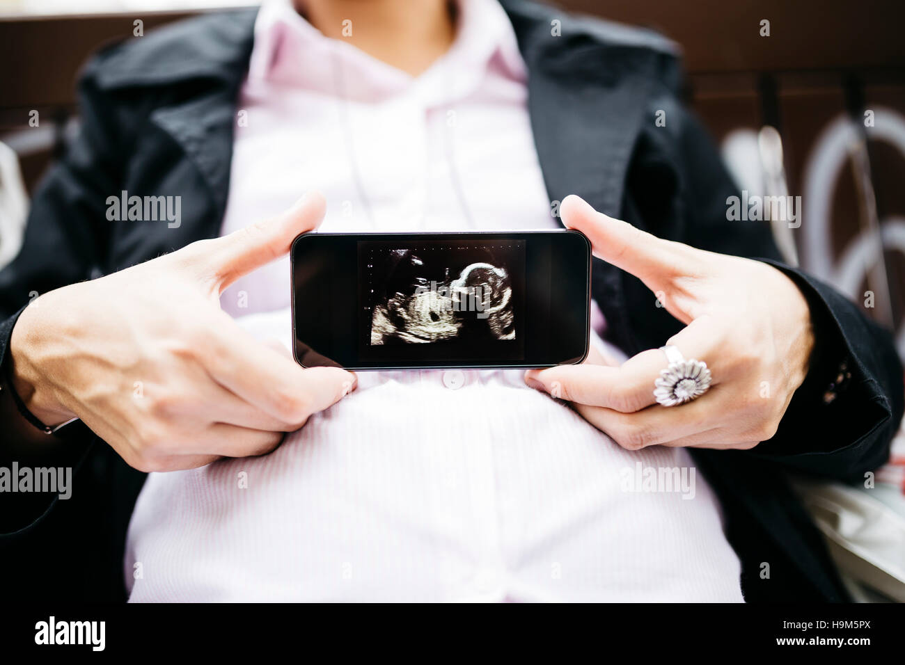 Pregnant woman showing ultrasound image on cell phone Stock Photo - Alamy