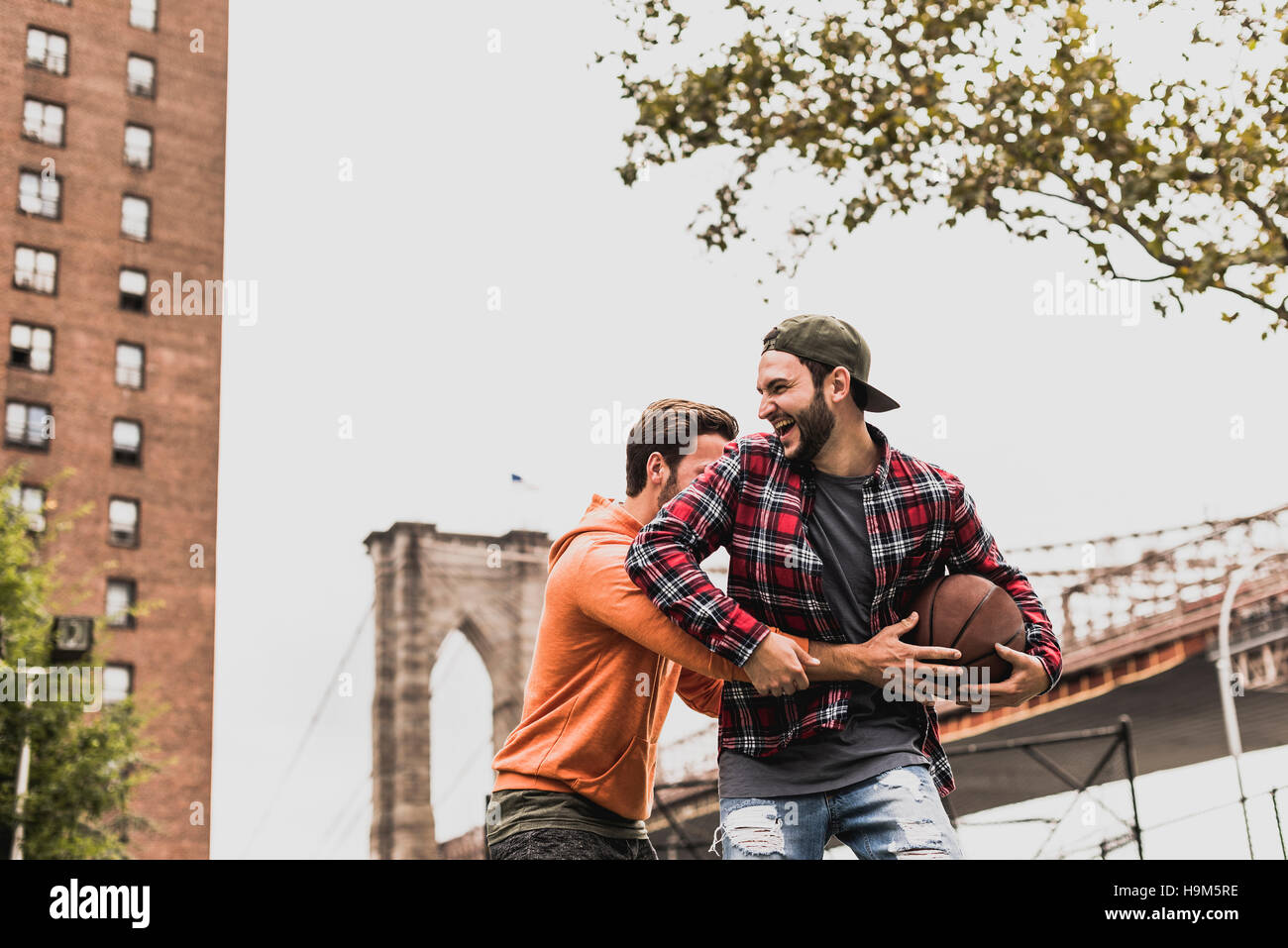 USA, New York, two young men with basketball having fun on an outdoor ... USA, New York, two young men with basketball having fun on an outdoor ...