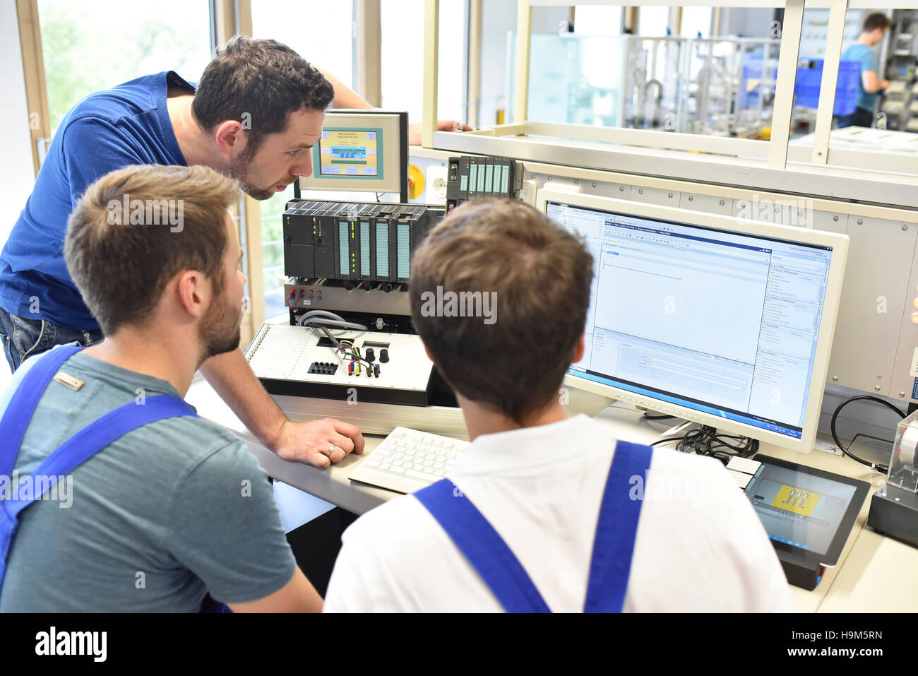 Technical instructor teaching students at computer screen Stock Photo ...