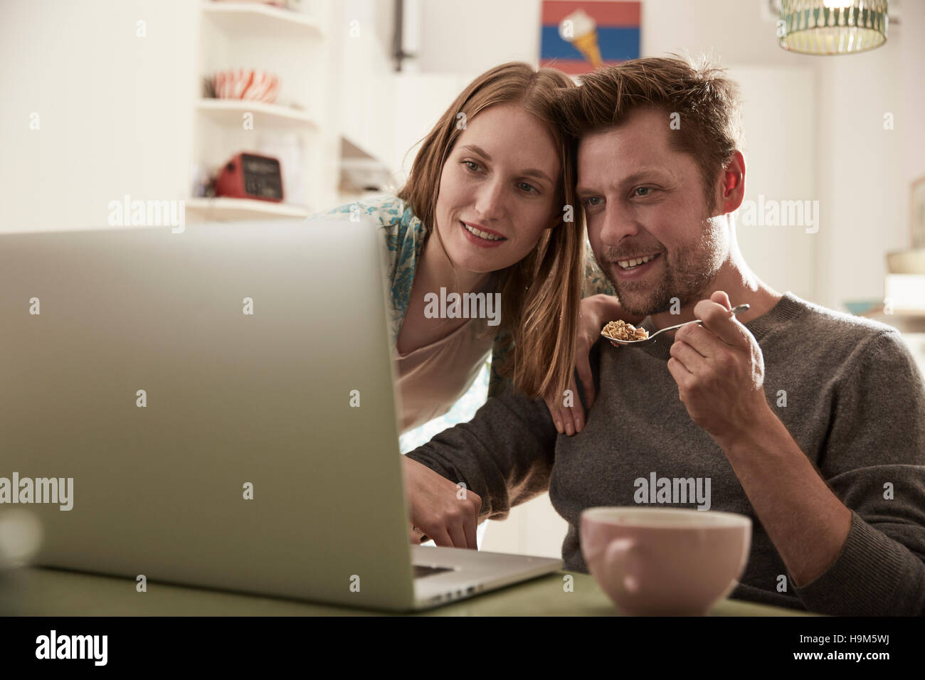 Couple looking at laptop together Stock Photo - Alamy