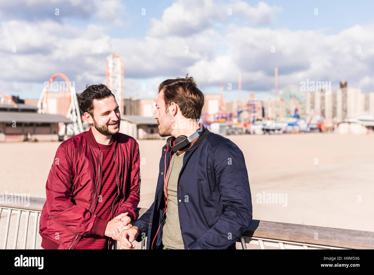 USA, New York City, two friends talking on bridge on Coney Island Stock ...