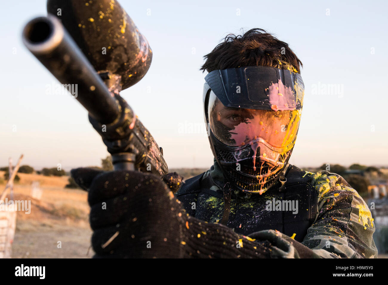 Paintball player with paintball mask and paintball gun stained with ...