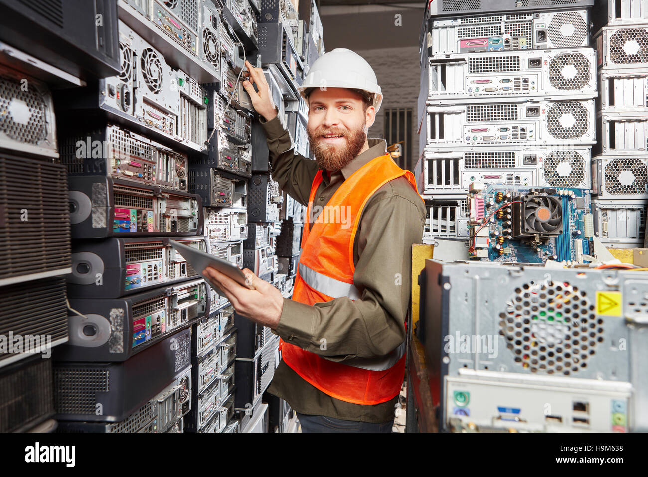 Worker in computer recycling plant using digital tablet Stock Photo - Alamy