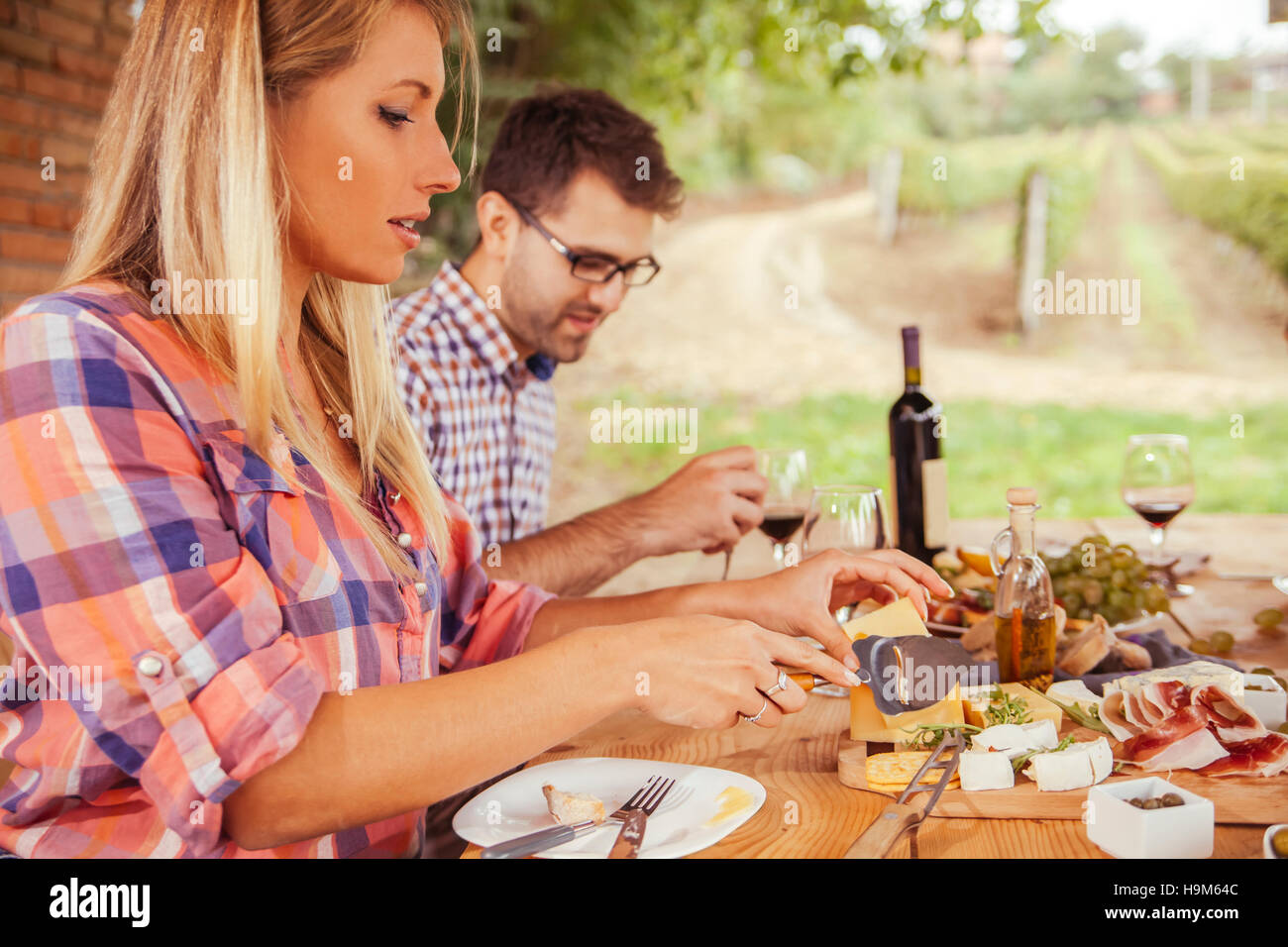 Couple eating at outdoor table Stock Photo - Alamy